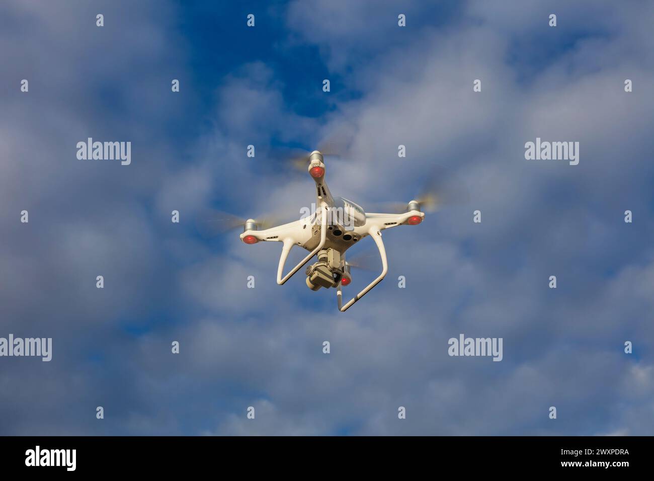 Drone flying in blue sky Stock Photo - Alamy
