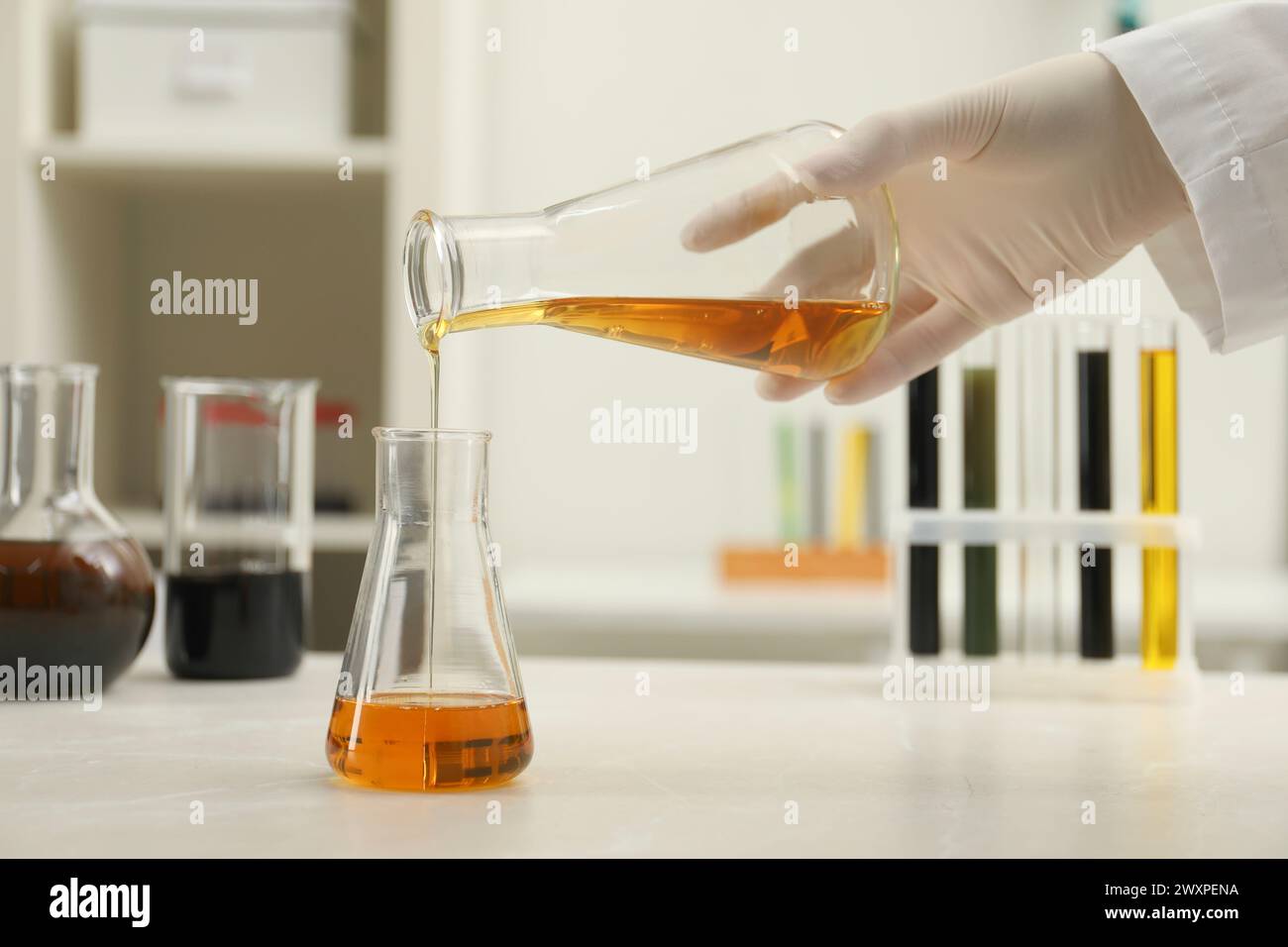 Lab worker pouring orange hi-res stock photography and images - Alamy