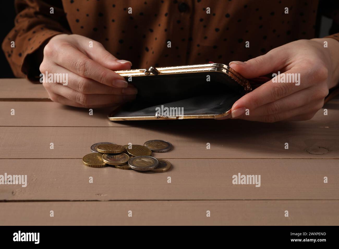 Poverty. Woman with empty wallet and coins at wooden table, closeup ...