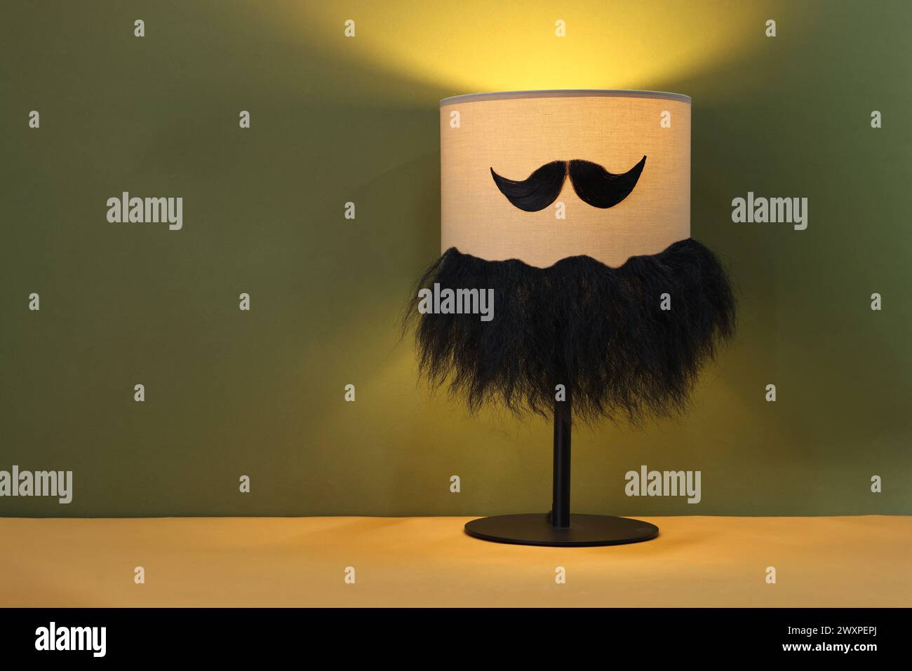 Man's face made of artificial mustache, beard and lamp on khaki ...