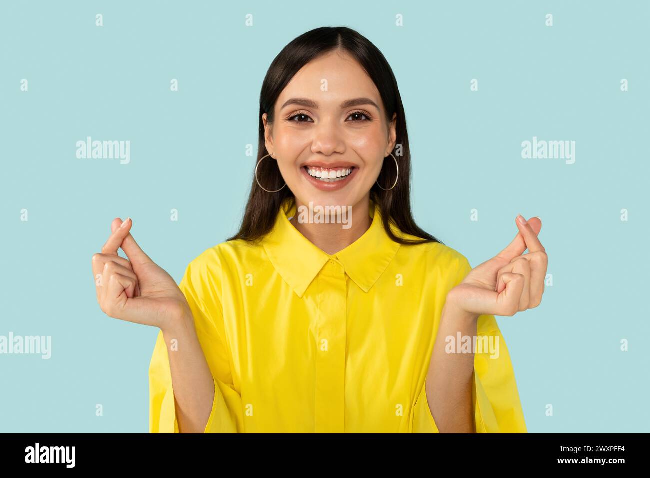 Portrait of beautiful smiling young woman making Korean finger mini ...
