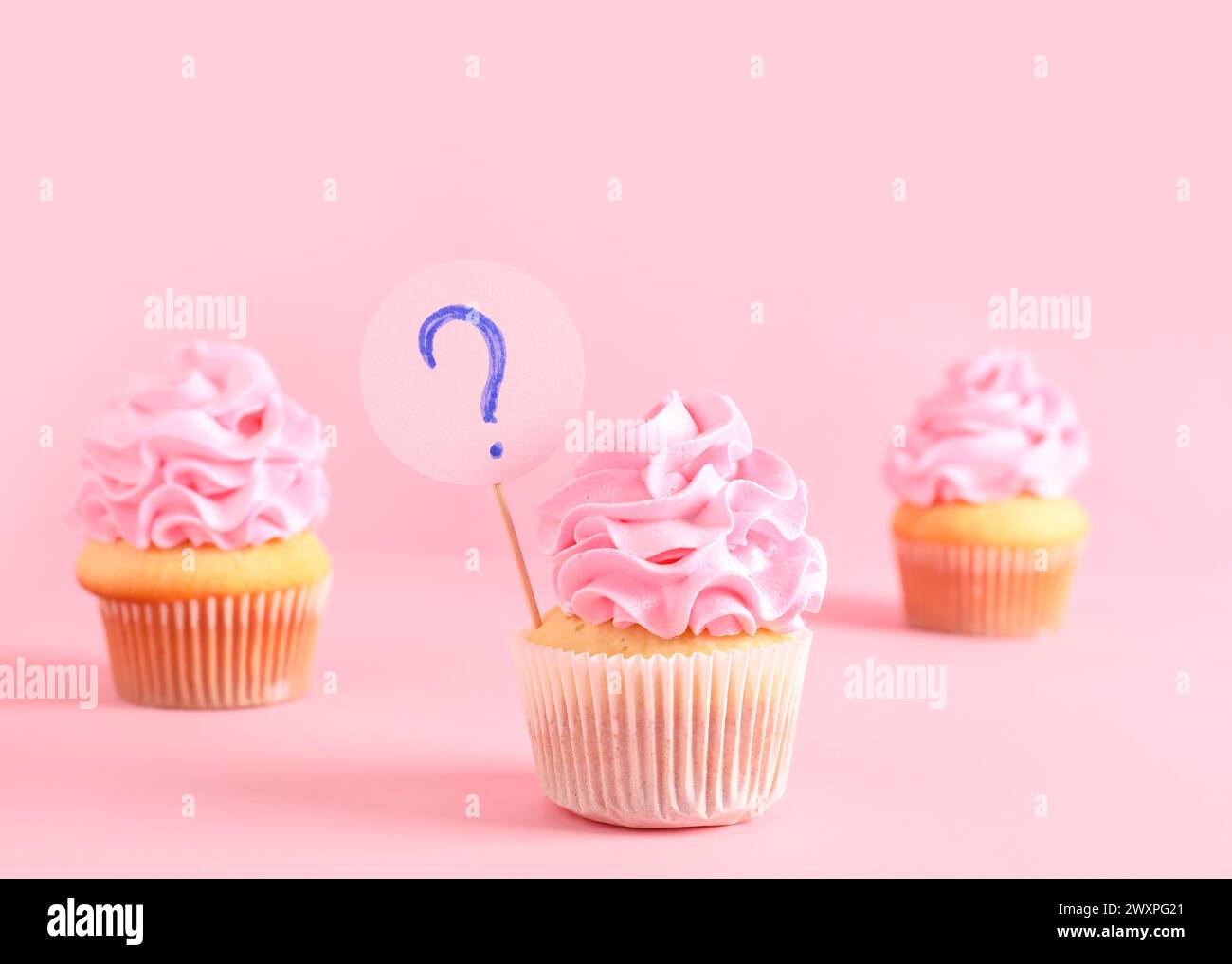 Delicious cupcakes with question mark on pink background. Gender reveal ...