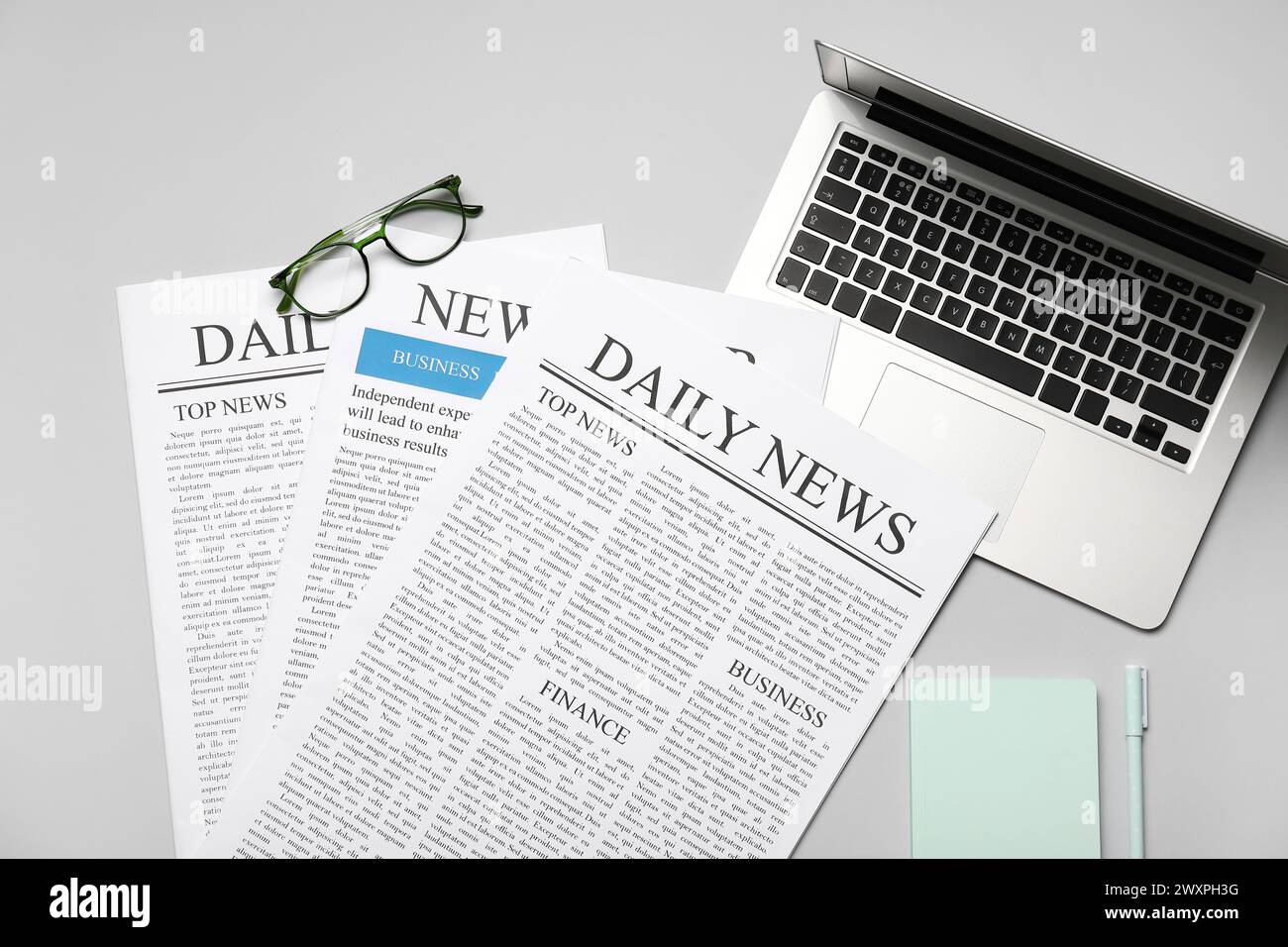 Newspapers with laptop, notebook and eyeglasses on white background ...