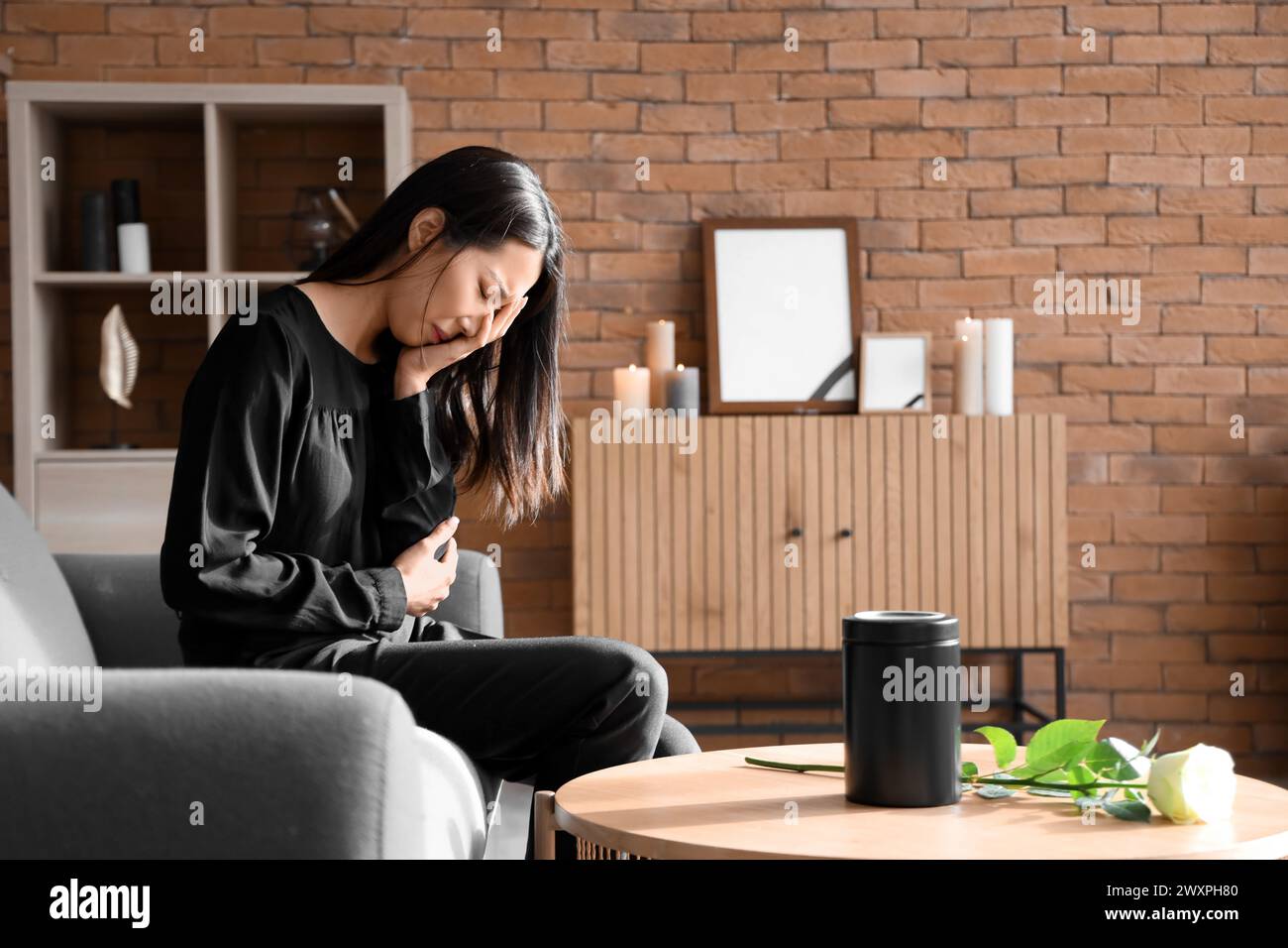 Grieving young Asian woman crying near mortuary urn at funeral Stock ...
