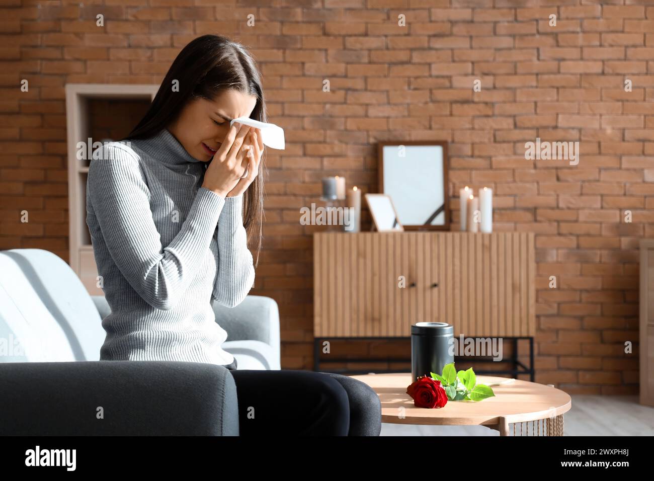Mourning young woman crying near mortuary urn at funeral Stock Photo ...