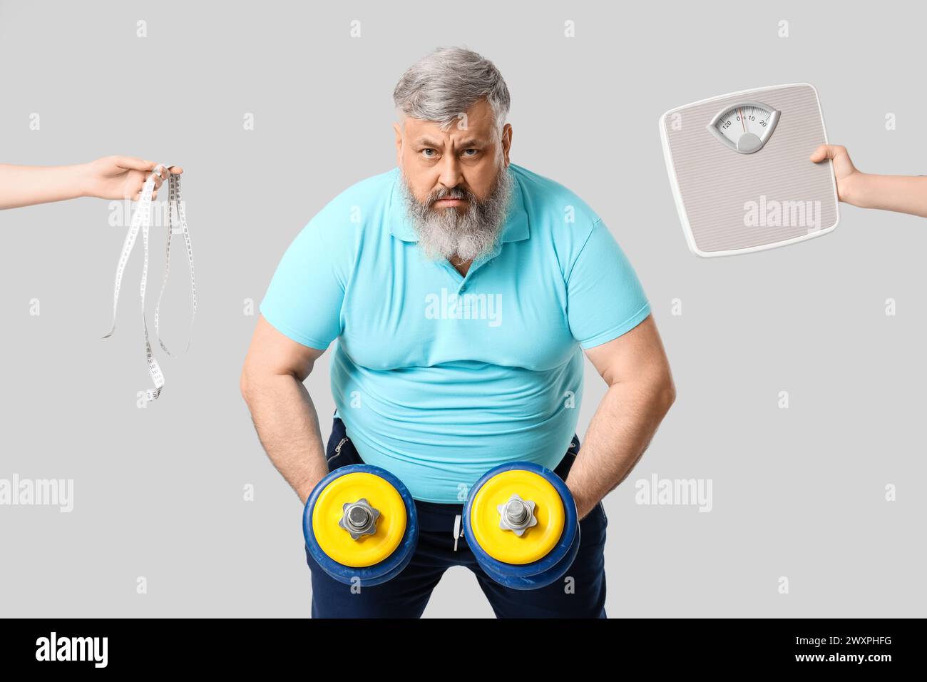 Overweight mature man with dumbbells and hands holding scales ...
