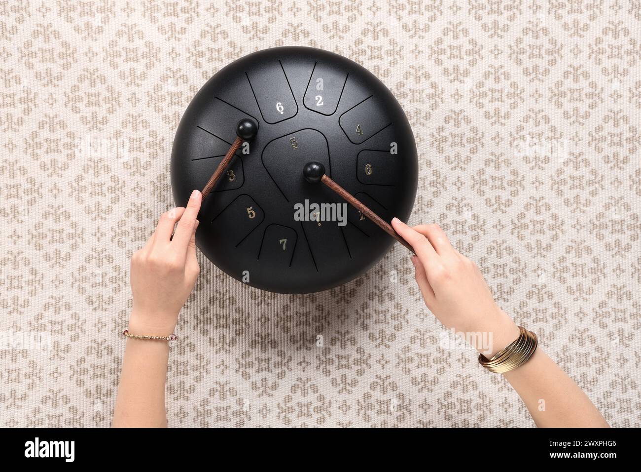 Female hands with sticks playing glucophone on color background Stock ...