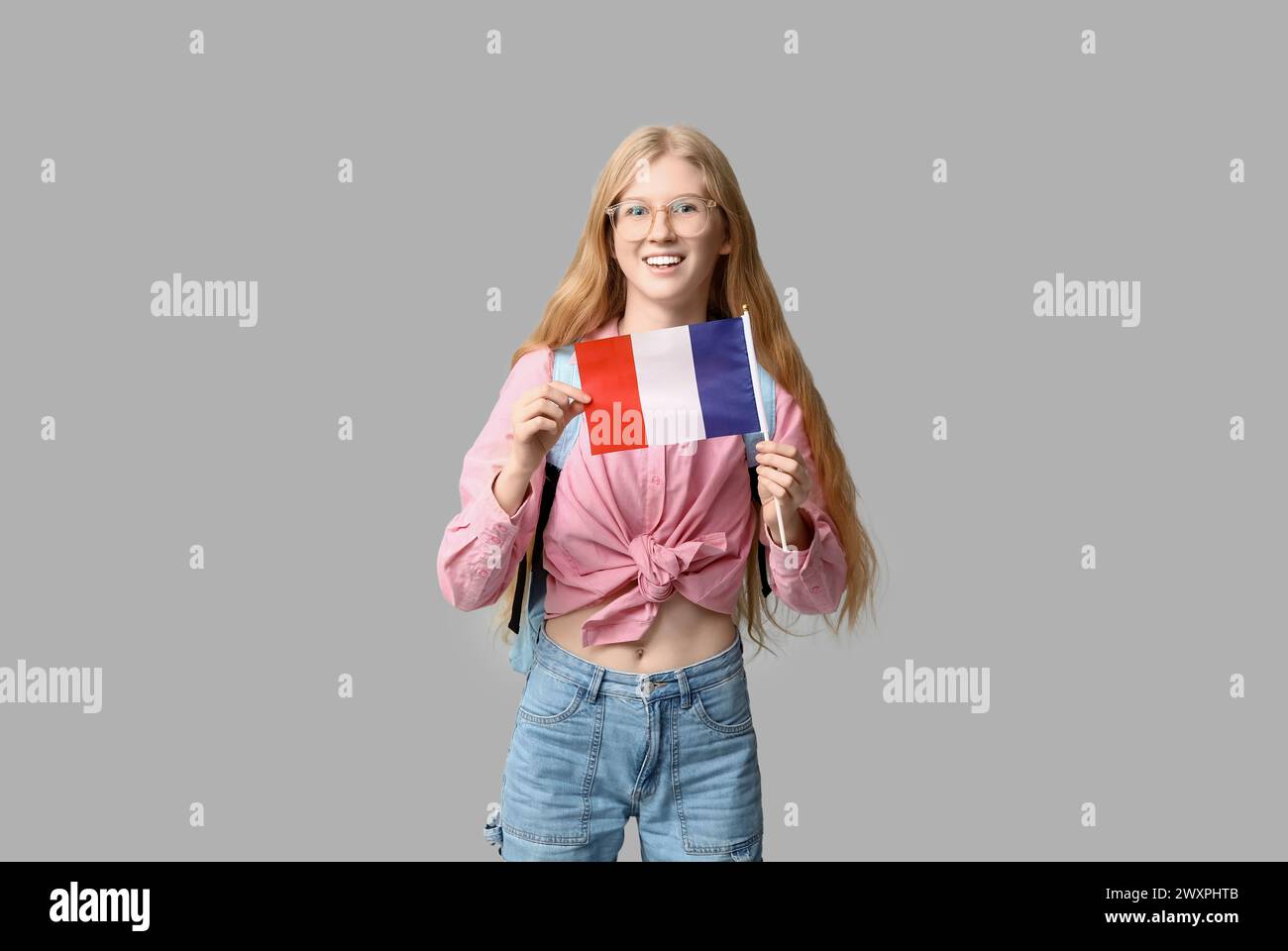 Female student with French flag on grey background Stock Photo - Alamy