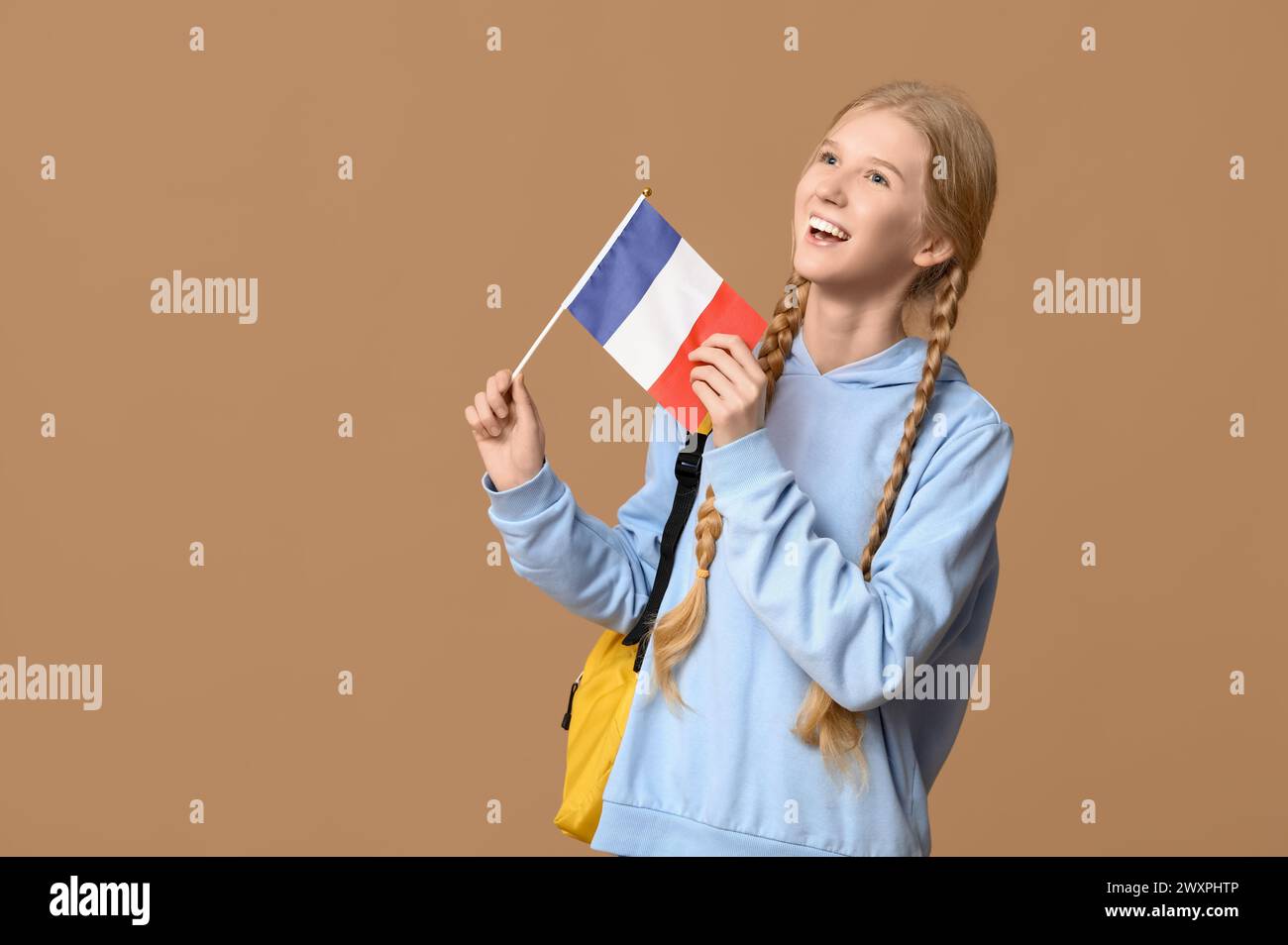 Female student with French flag on beige background Stock Photo - Alamy