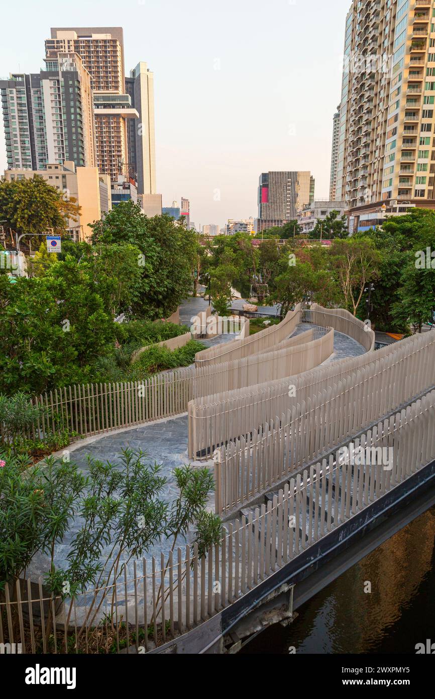 View of the empty and lush Chong Nonsi Canal Park and skyscrapers and ...