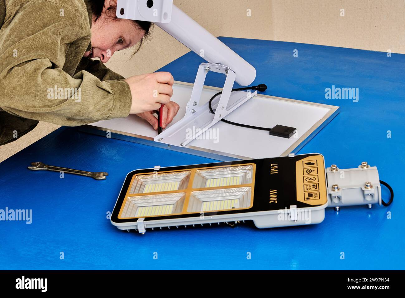 Assembling stand alone solar street light, an electrician attaches ...