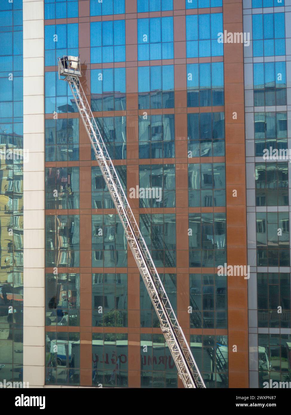 Cleaning windows in a large glass building. Work at height on a lift ...