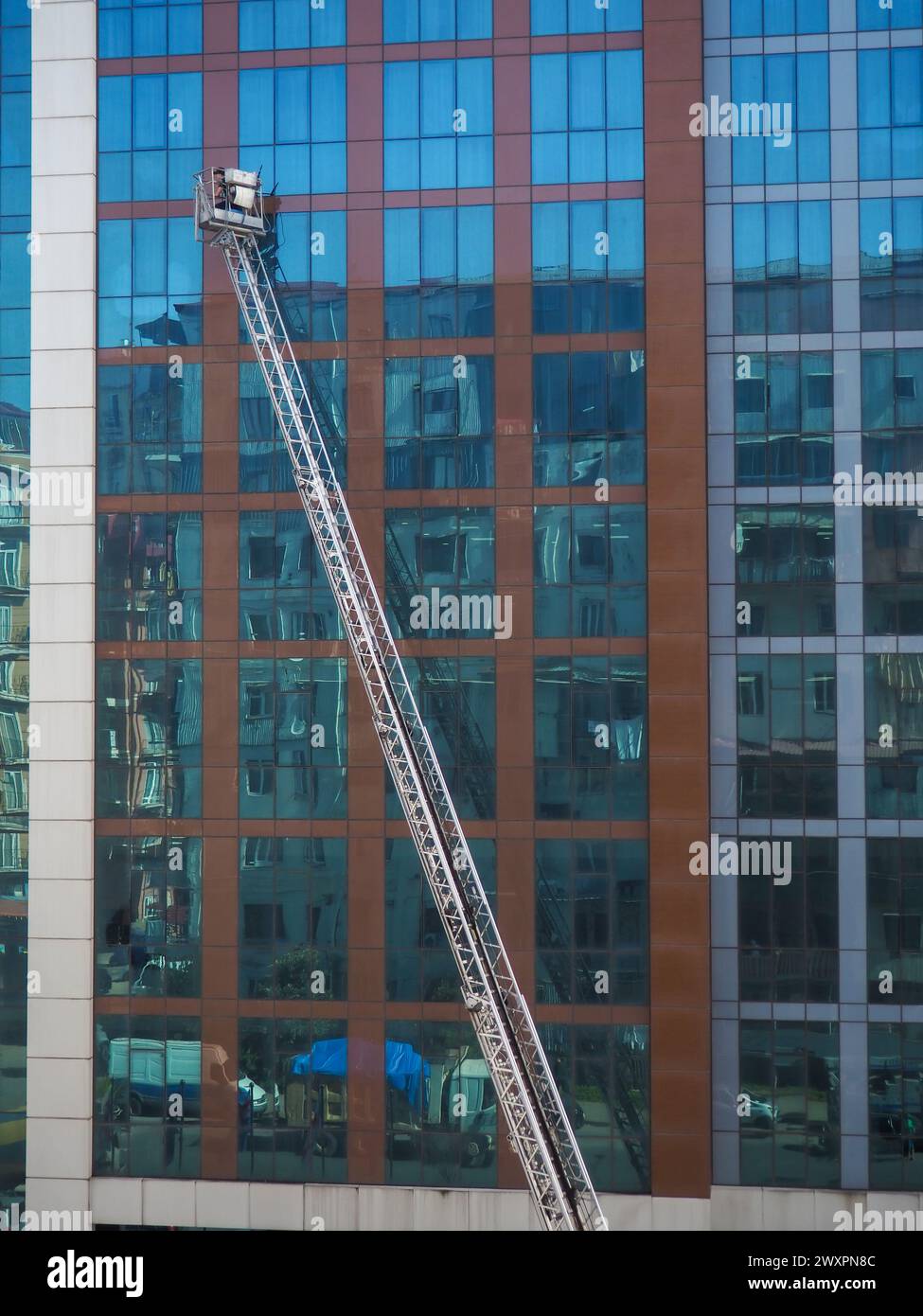 Cleaning windows in a large glass building. Work at height on a lift ...