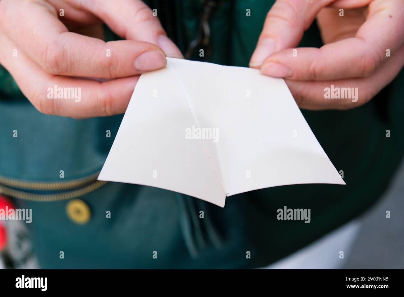 The person is holding a piece of paper in their hand, using their ...