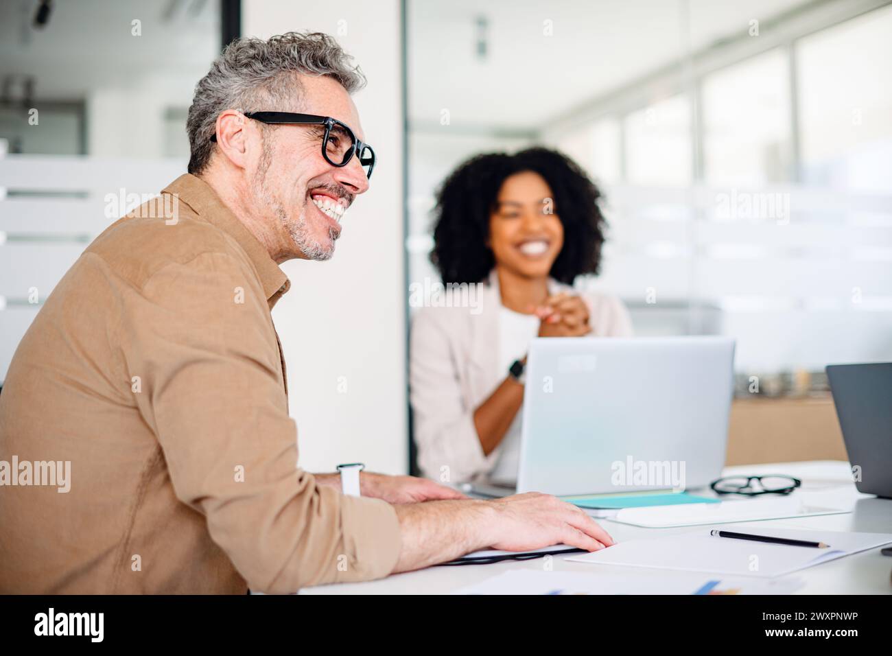 Business meeting where a male professional laughs wholeheartedly ...