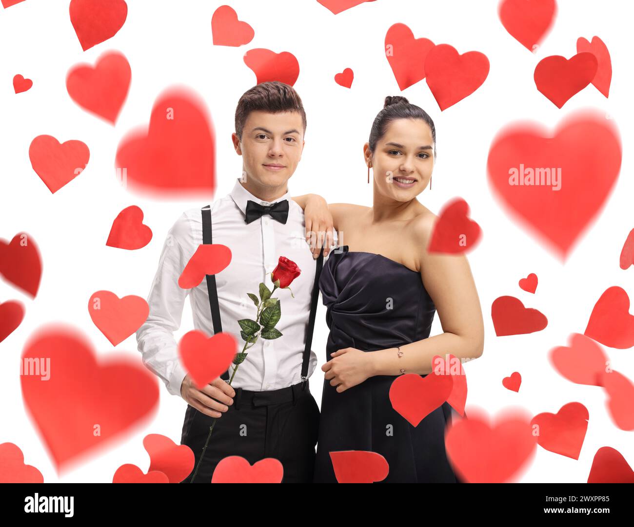 Couple celebrating prom night and standing under red hearts isolated on ...