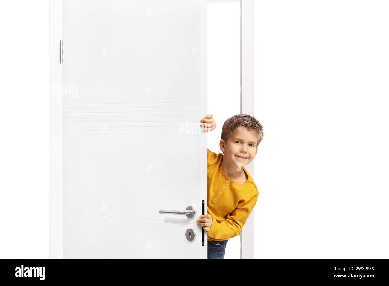 Cute little boy hiding behind a door Stock Photo - Alamy