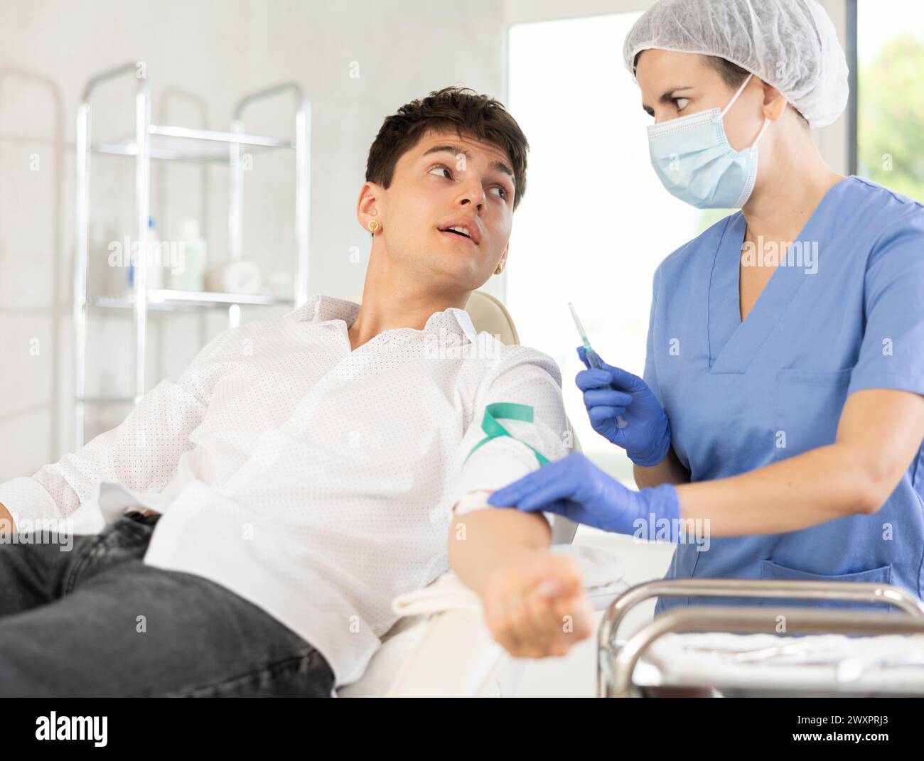 Anesthesiologist doctor injecting pain medication into vein of man ...