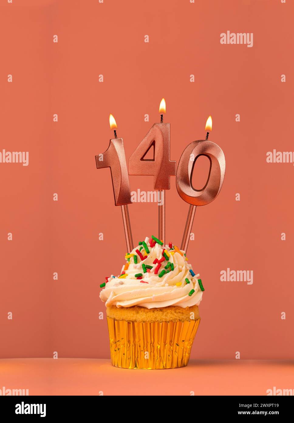Birthday cupcake with candle number 140 - Coral fusion background Stock Photo - Alamy