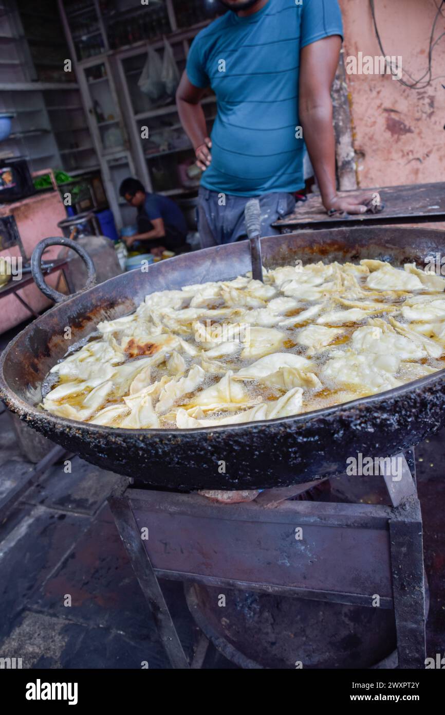 Traditional Namkeen Indian snacks and Samosas frying on street food and ...