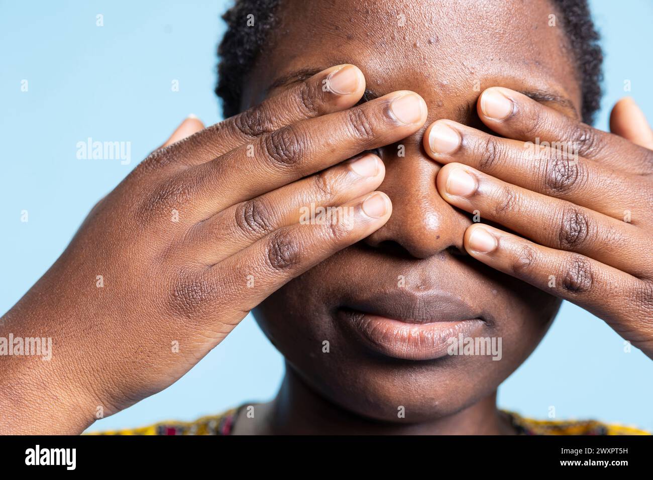 Young adult presenting three wise monkey sign in studio, covering her ...