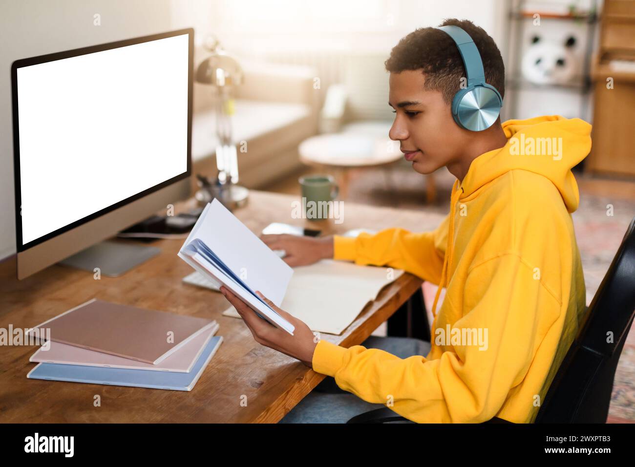 Student studying with notebook and computer at desk Stock Photo - Alamy