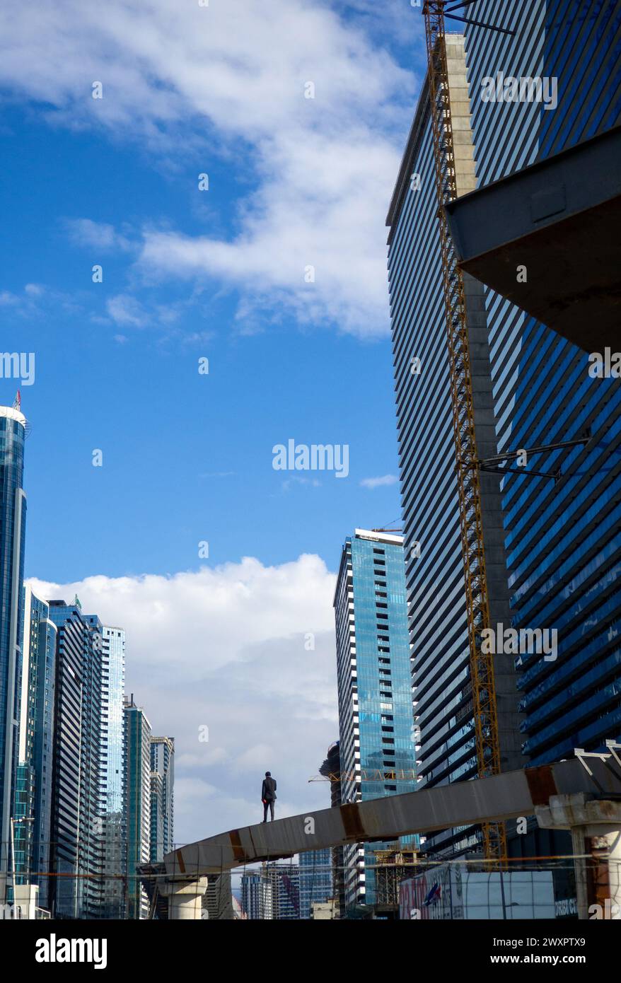 Construction of a high-rise building in Asia. A man among tall ...