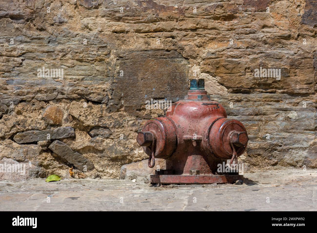 A very old hydrant half buried in a street of the colonial town of ...
