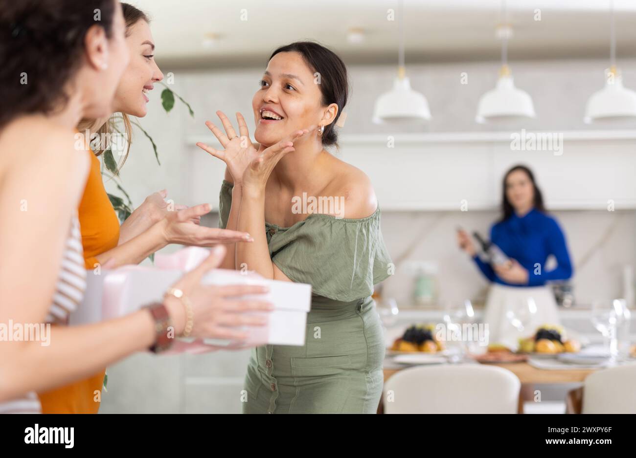 Group of women greeting each other and giving gift Stock Photo - Alamy