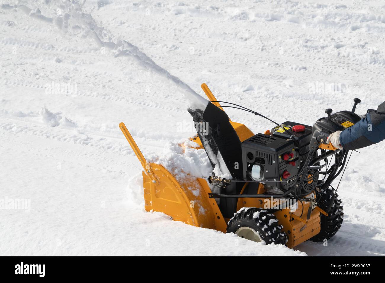 Operator machine using snowblower to remove snow from road after winter ...