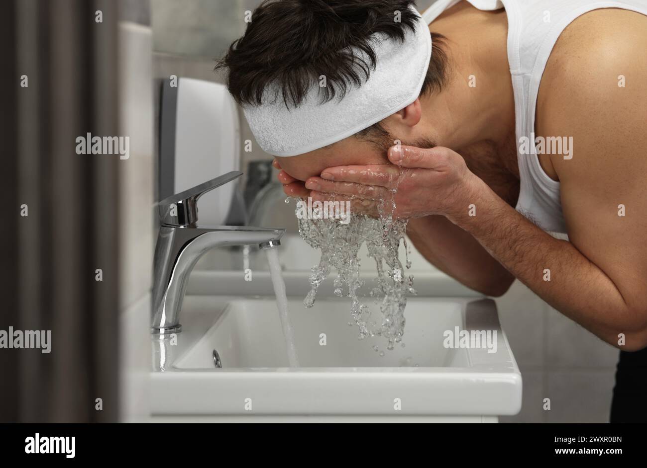 Man washing face in sink hi-res stock photography and images - Alamy