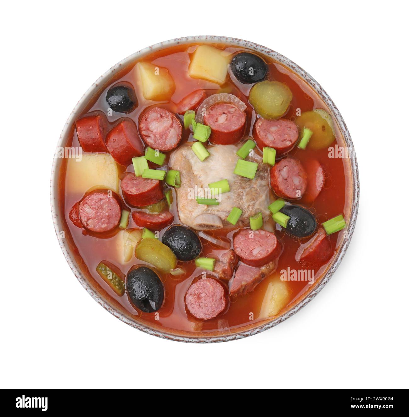Meat solyanka soup with thin dry smoked sausages in bowl isolated on ...