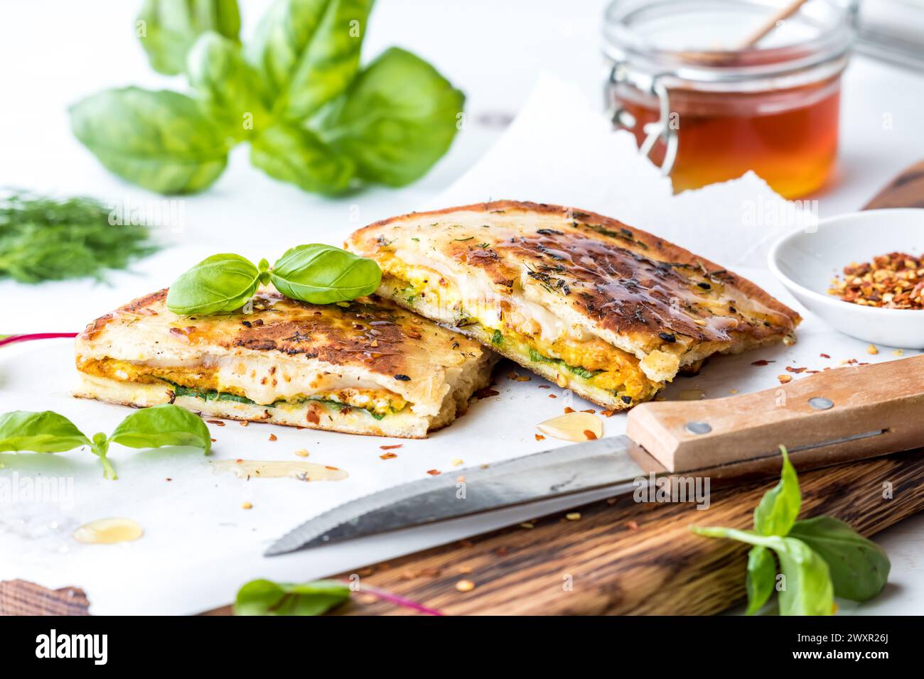 Naan bread breakfast sandwiches topped with honey and basil, ready for ...