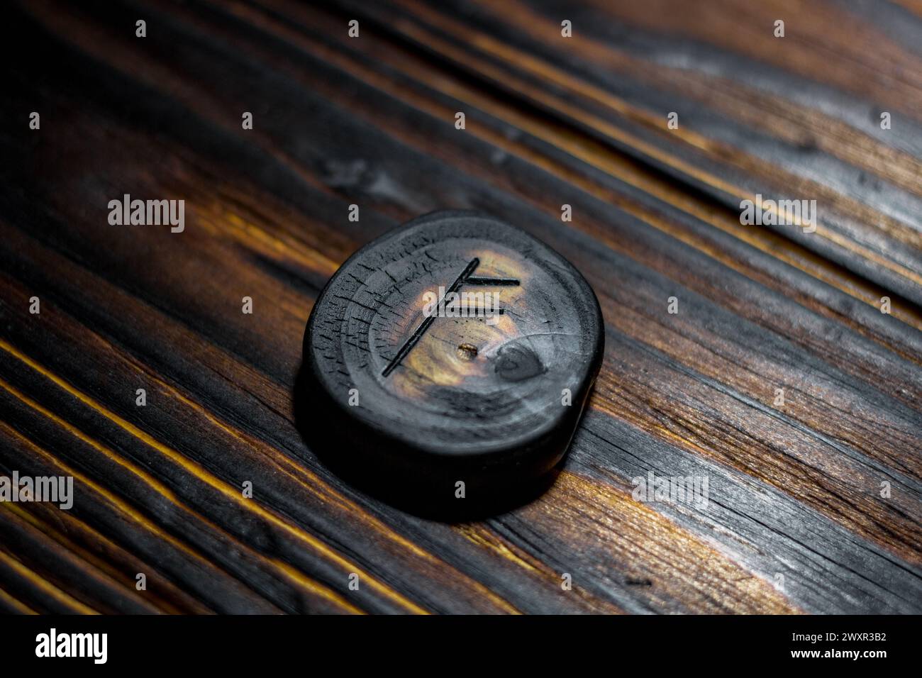 Rune Fehu carved from wood on a wooden background - Elder Futhark Stock ...