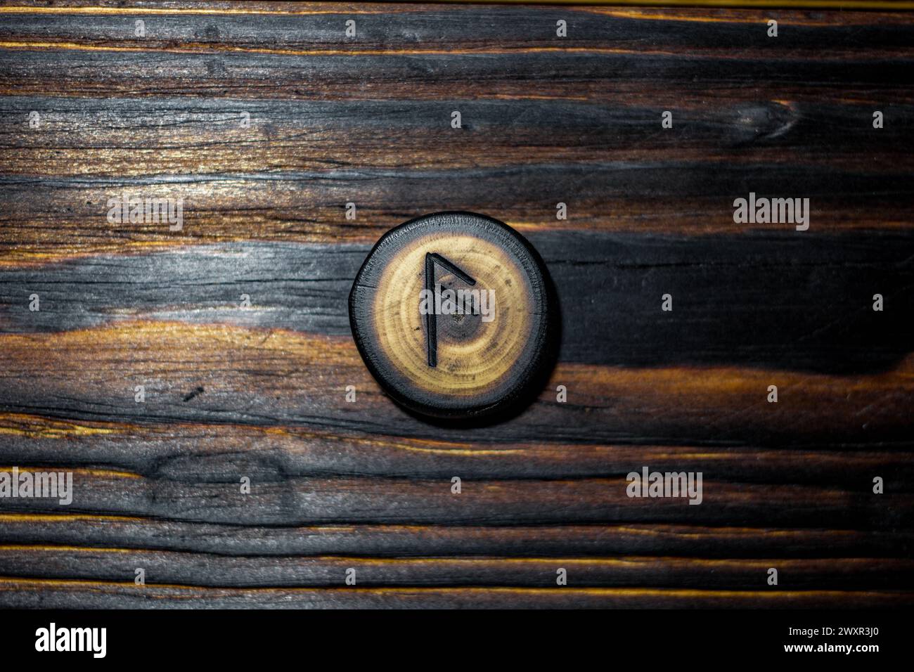 Rune Ansuz carved from wood on a wooden background - Elder Futhark ...