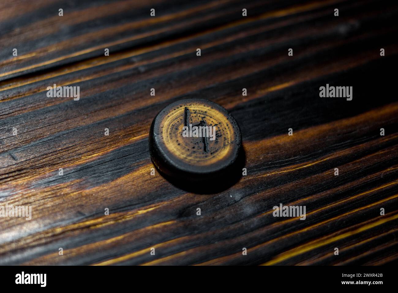 Rune Sowilo (Sigel, Sol) carved from wood on a wooden background ...