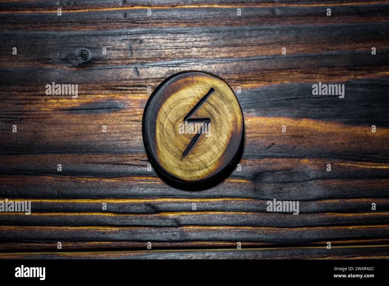 Rune Sowilo (Sigel, Sol) carved from wood on a wooden background ...