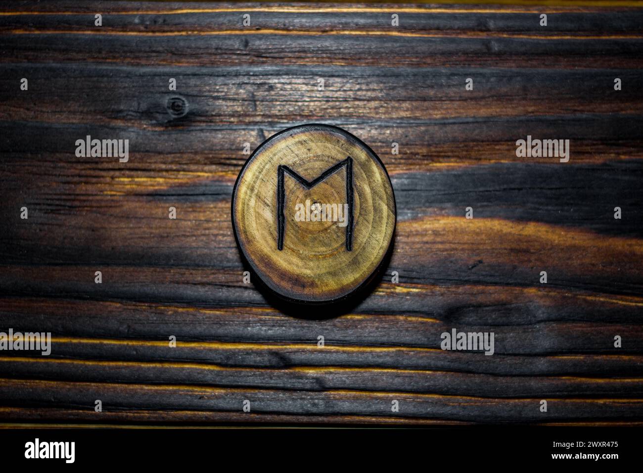 Rune Ehwaz carved from wood on a wooden background - Elder Futhark ...