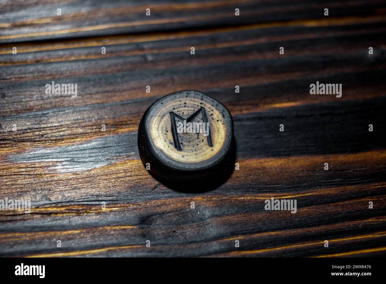 Rune Ehwaz carved from wood on a wooden background - Elder Futhark ...