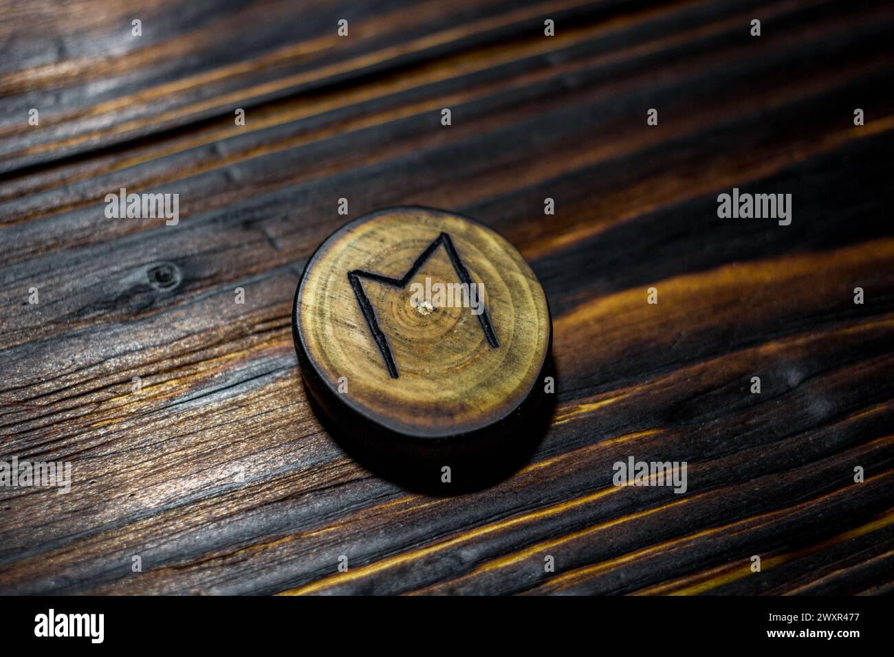 Rune Ehwaz carved from wood on a wooden background - Elder Futhark ...