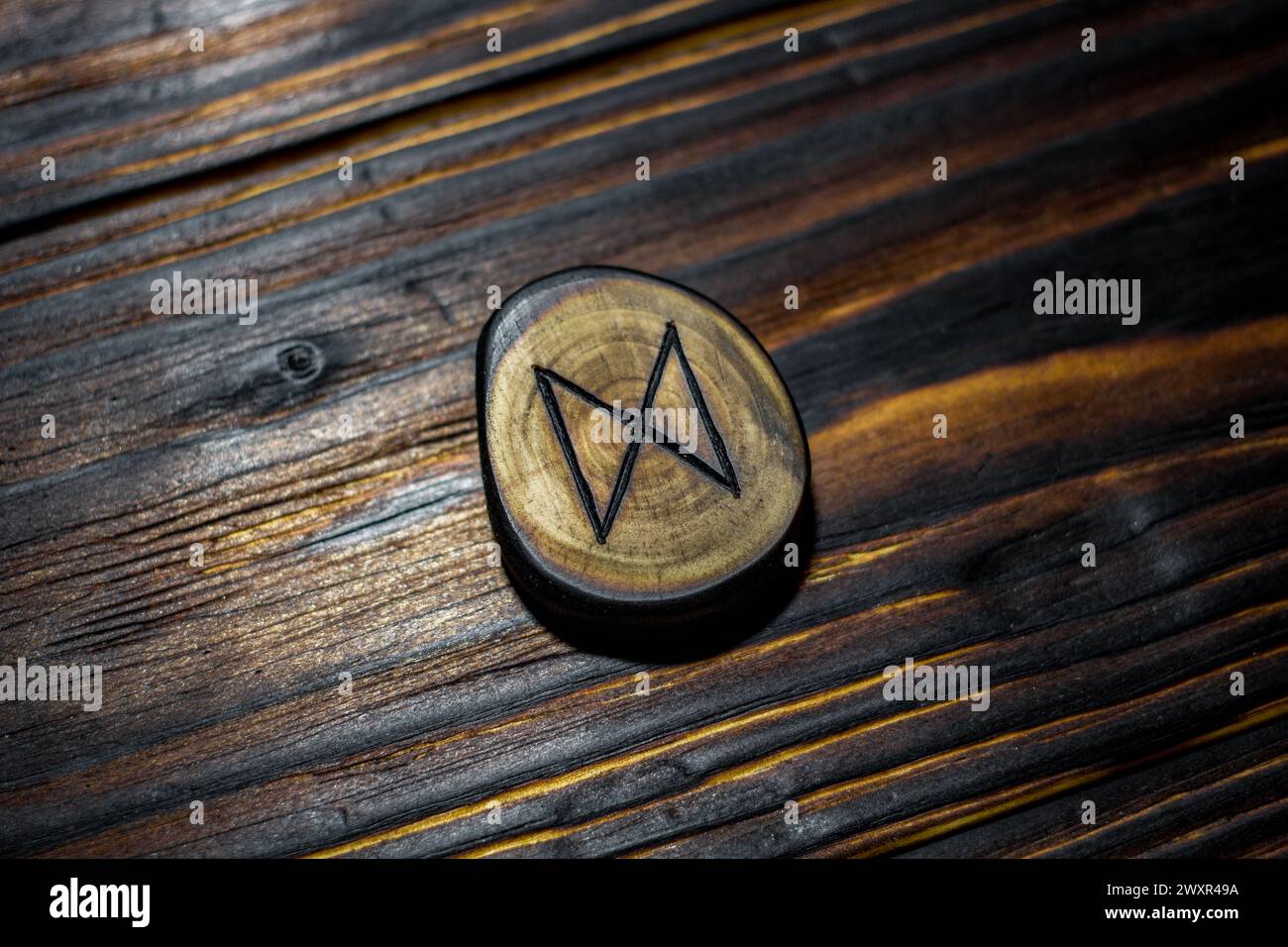 Rune Dagaz carved from wood on a wooden background - Elder Futhark ...