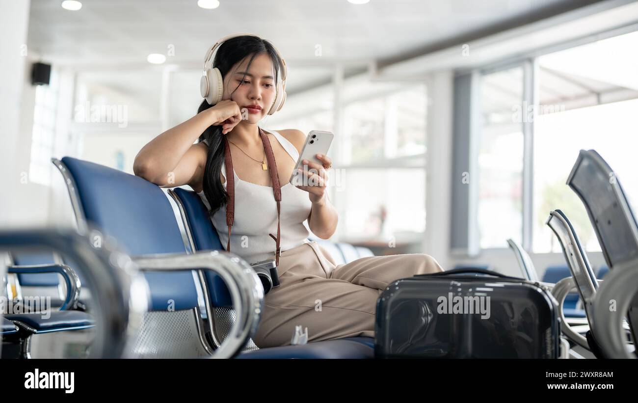 Woman scrolling smartphone airport gate hi-res stock photography and images - Alamy