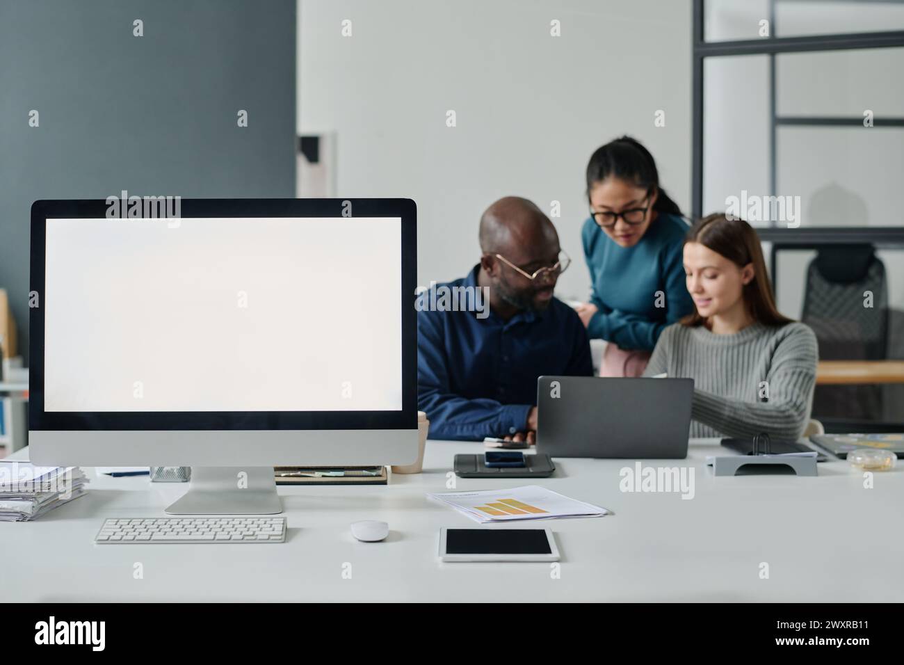 Selective focus shot of three ethnically diverse managers working on ...