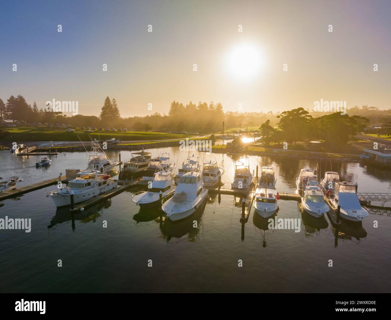 Aerial view of a foggy sunrise over a coastal marine full of boats at ...