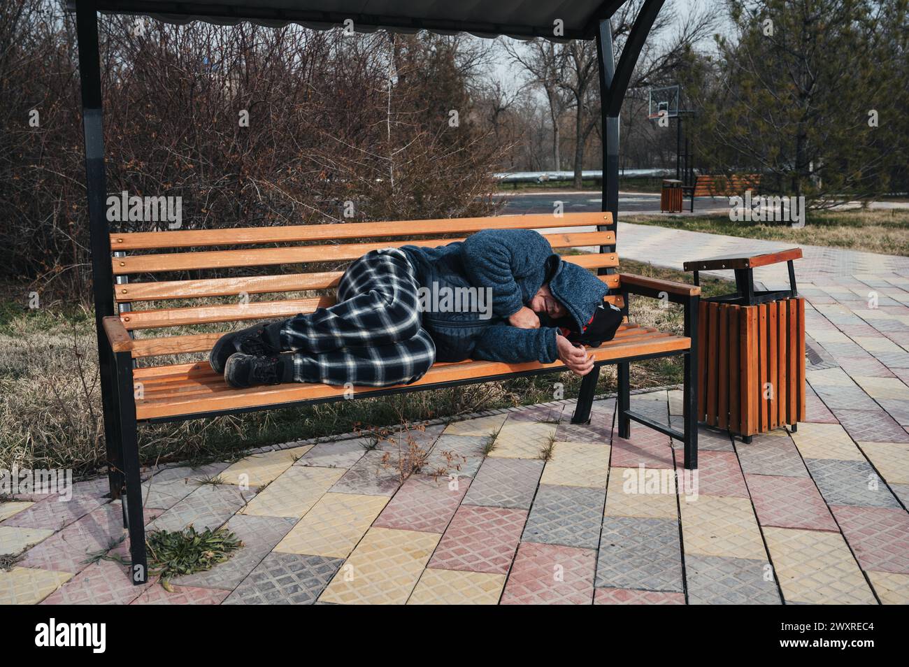 homeless elderly old man lies sleeping on a park bench in autumn Stock ...