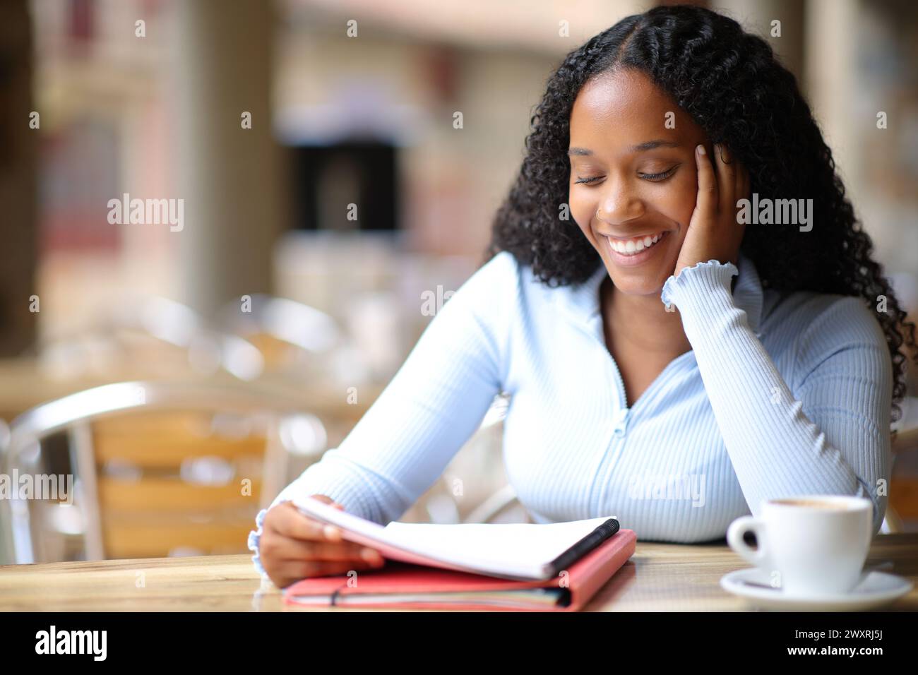 Happy black student memorizing notes in a coffee shop terrace Stock ...