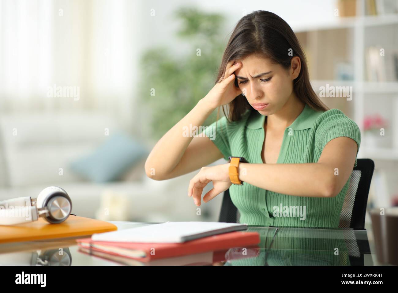 Worried student is checking her smartwatch sitting at home Stock Photo ...