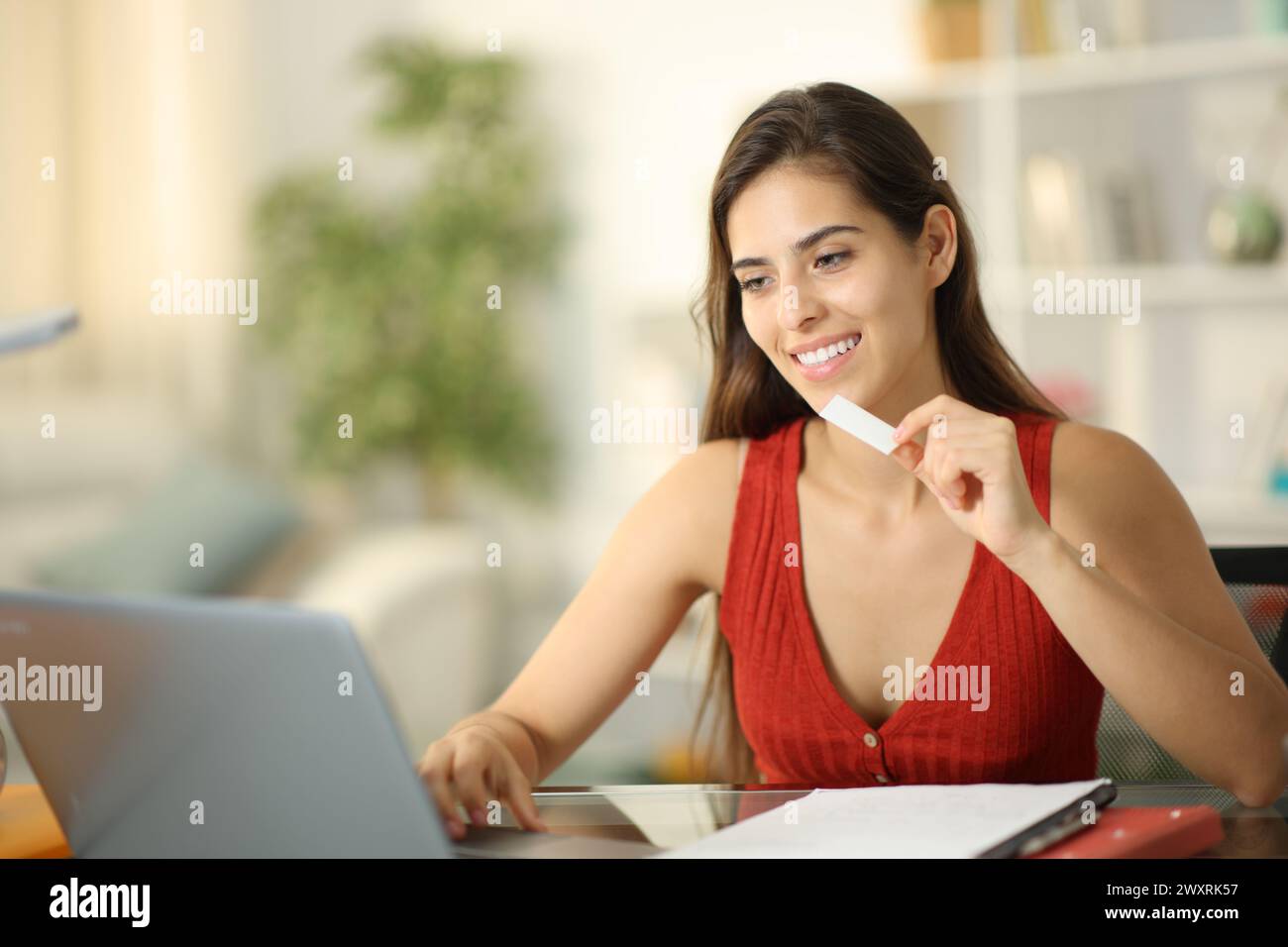 Happy student studying eating chewing gum at home Stock Photo - Alamy