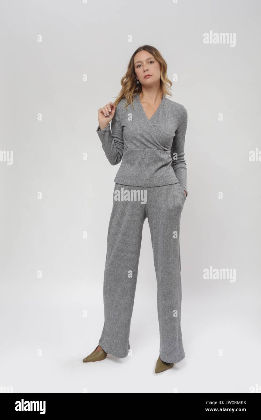 Serie of studio photos of female model in knitted grey set, autumn ...