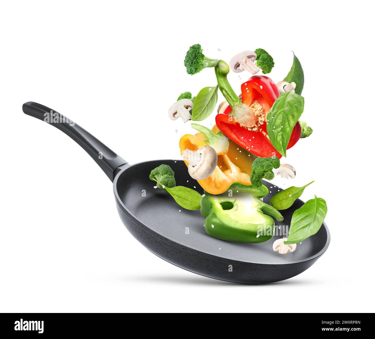 Frying pan with fresh ingredients in air on white background Stock ...